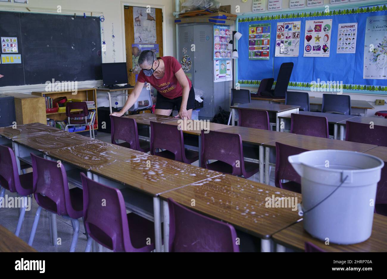 Die Klassenlehrerin Nancy Poirier wäscht die Schreibtische in ihrem ...