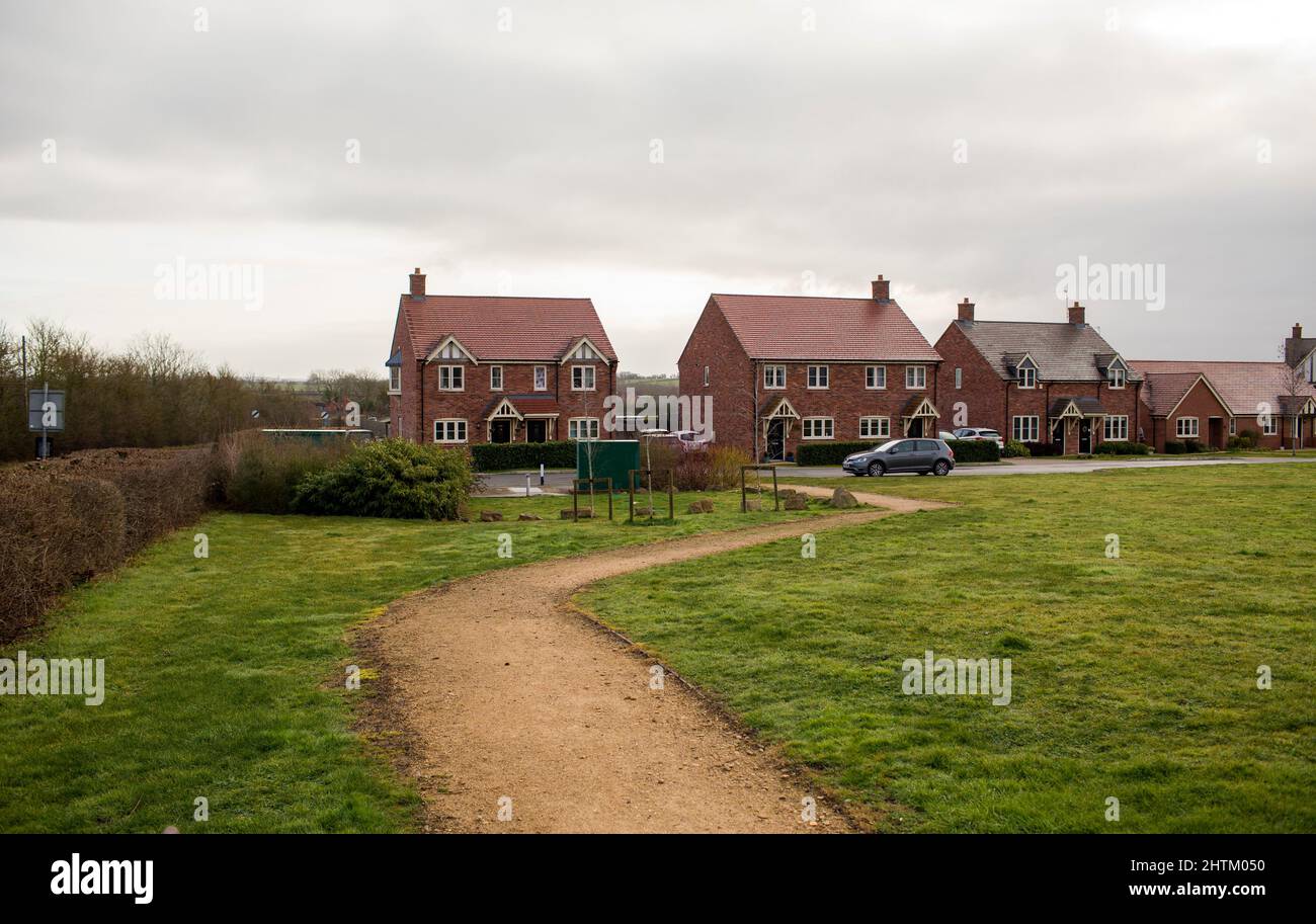 Neu gebaute Häuser am Rande des Grüns in Grafton Flyford. Sie sind rund ...
