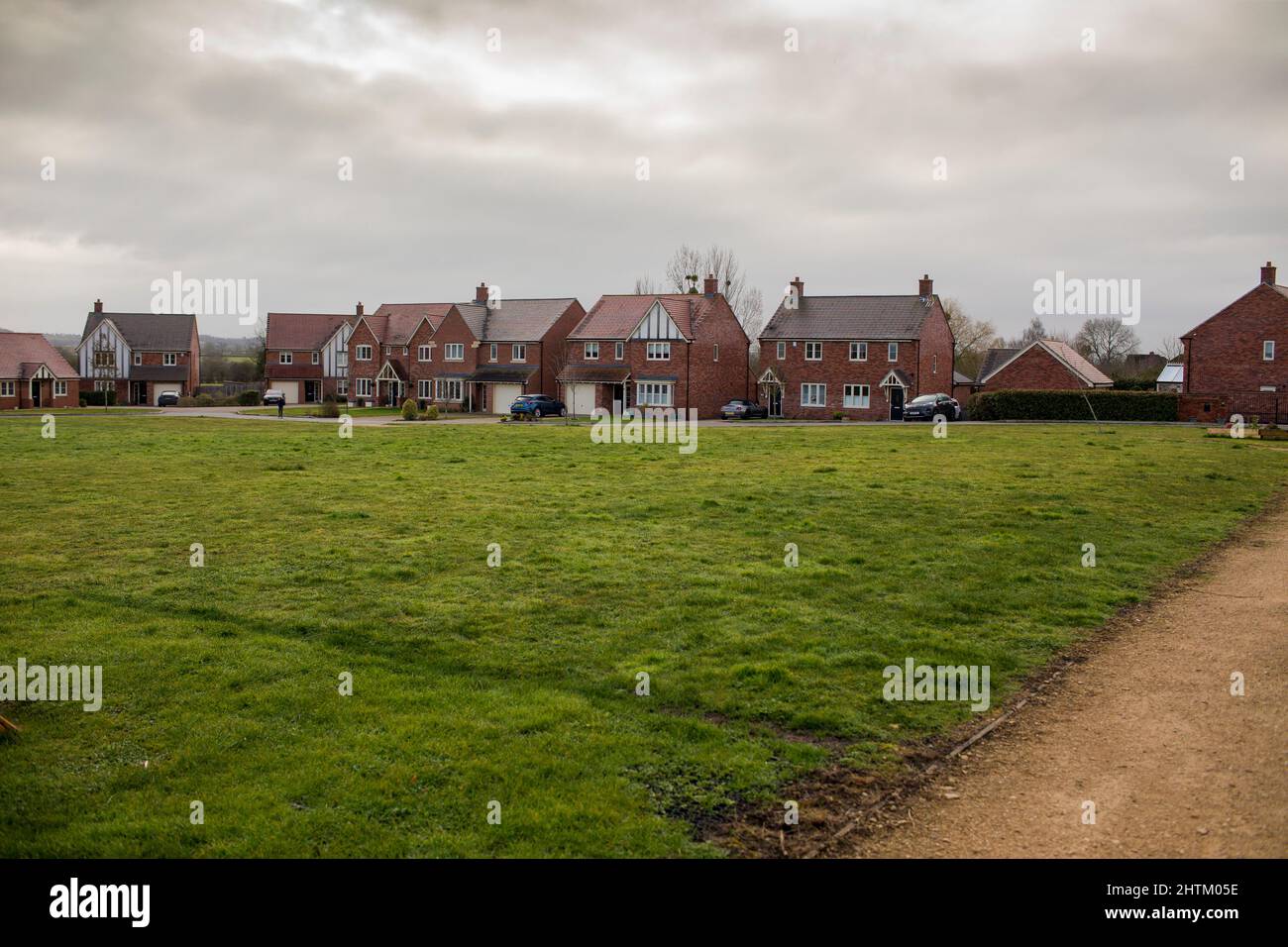 Neu gebaute Häuser am Rande des Grüns in Grafton Flyford. Sie sind rund ...