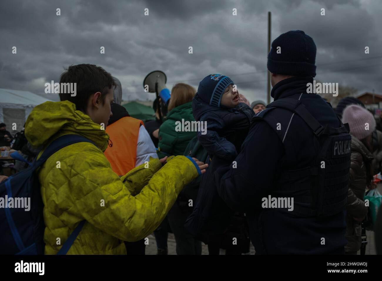 Medyka, Polen - 5. März 2022: Ein Polizist trägt ein Baby an Bord eines ... Medyka, Polen - 5. März 2022: Ein Polizist trägt ein Baby an Bord eines ...