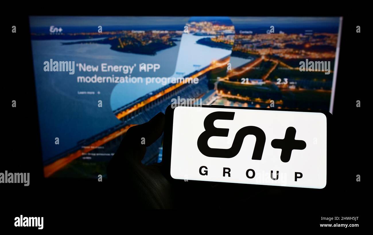 Person, die ein Mobiltelefon mit dem Logo des anglo-russischen ...