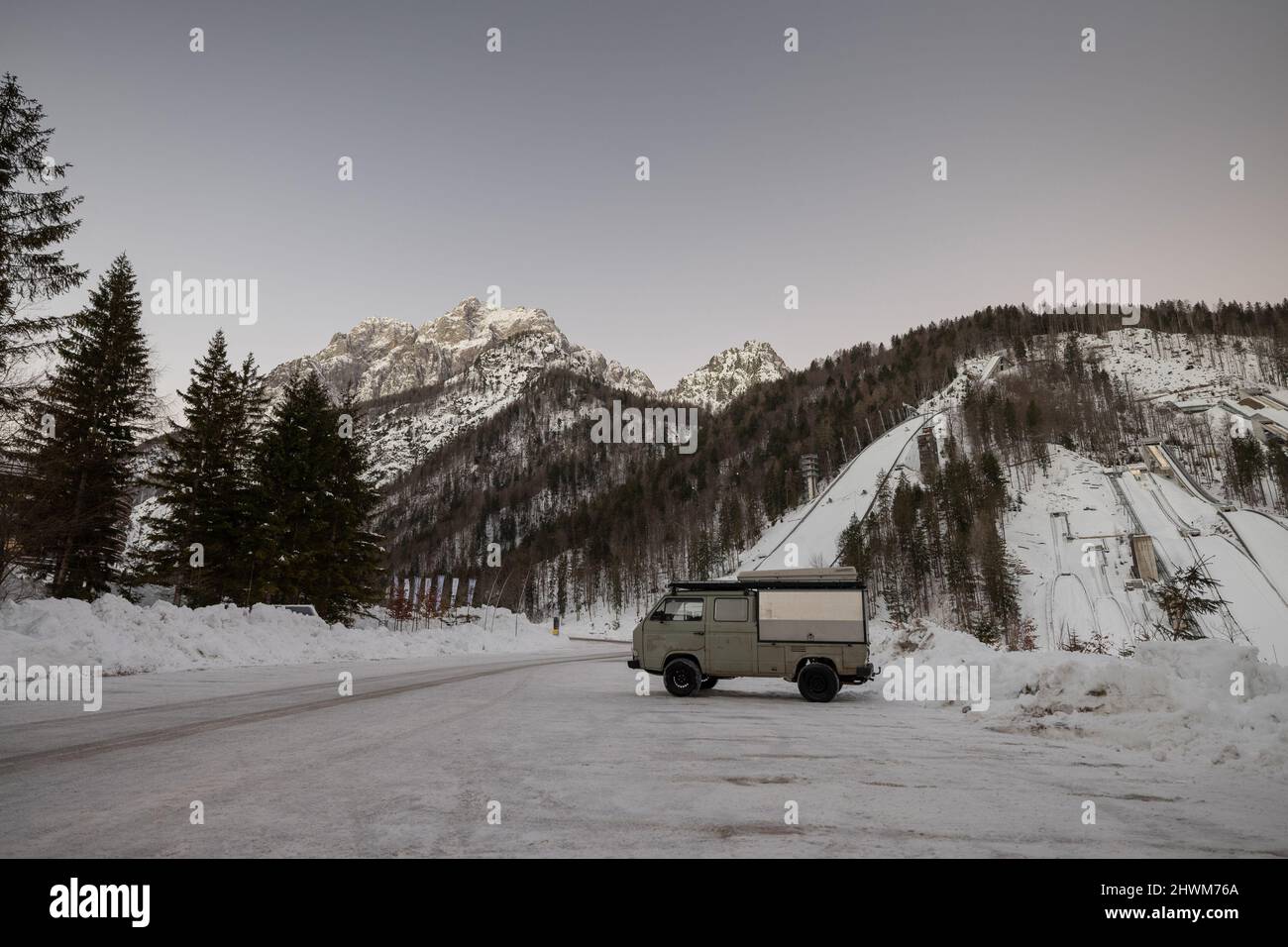 Der alte Abenteuercampervan ist auf einem mit Schnee bedeckten ...
