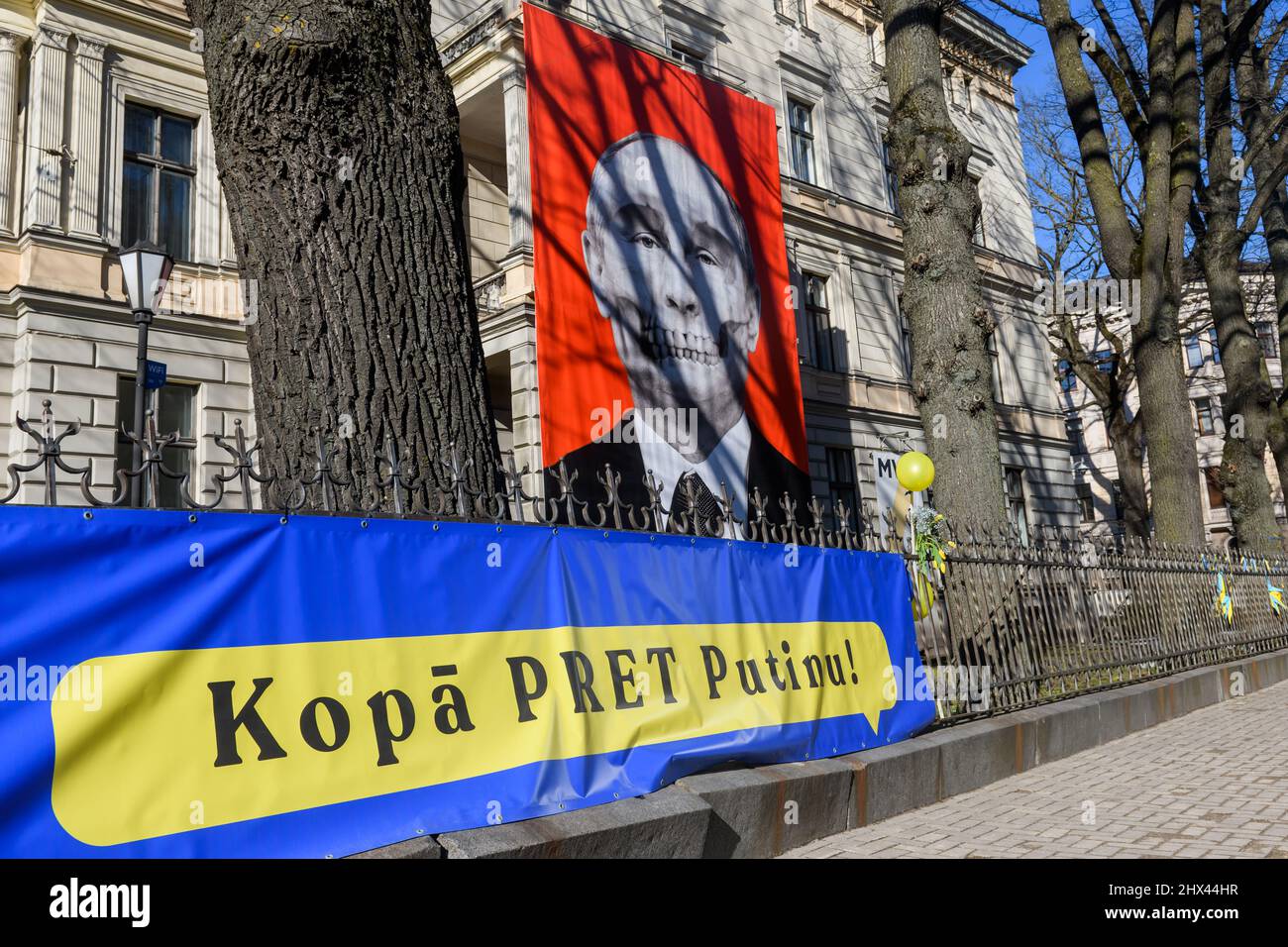RIGA, LETTLAND. 9.. März 2022. Riesiges Banner mit Putins Schädel, das ... RIGA, LETTLAND. 9.. März 2022. Riesiges Banner mit Putins Schädel, das ...