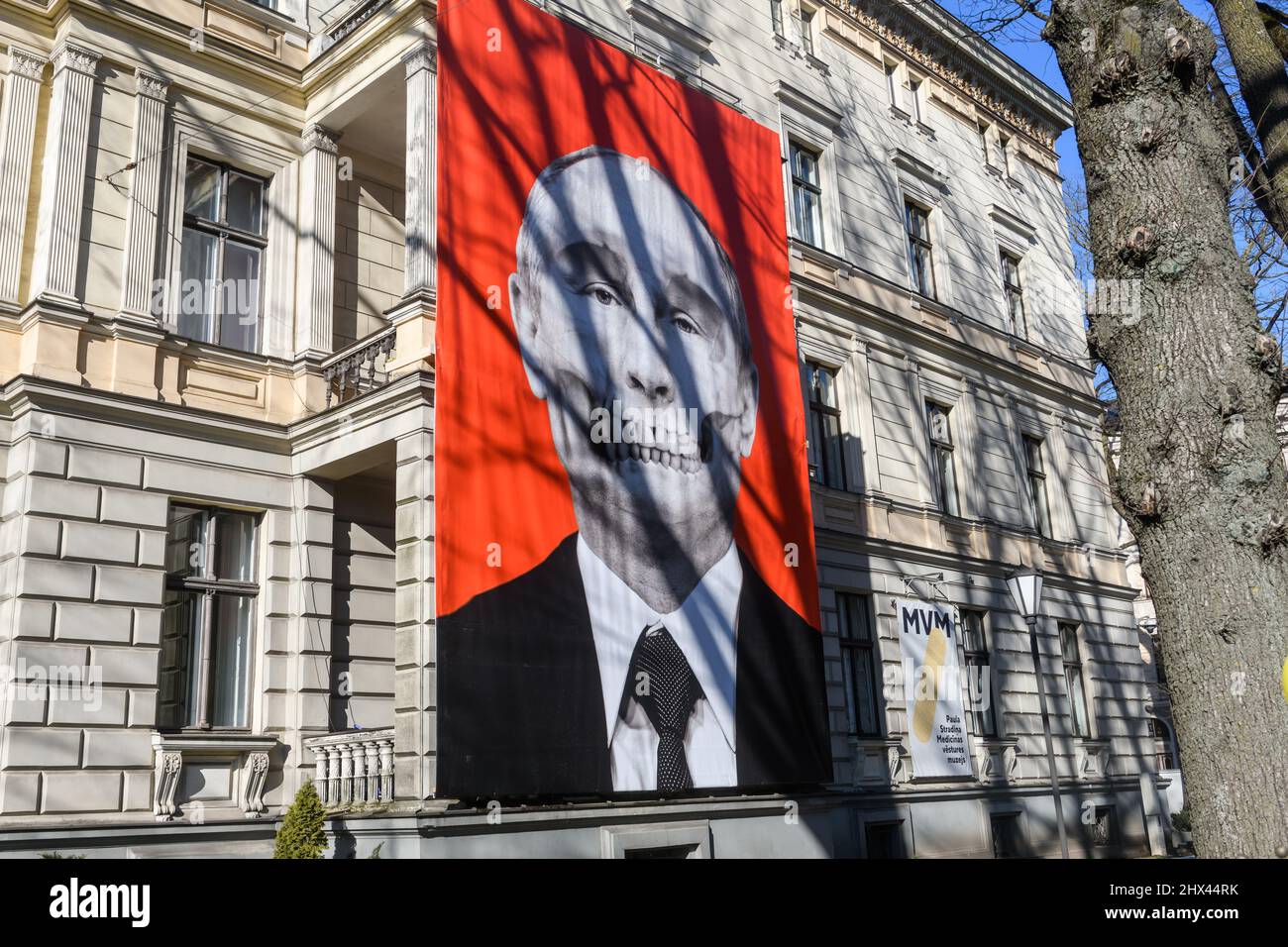 RIGA, LETTLAND. 9.. März 2022. Riesiges Banner mit Putins Schädel, das ... RIGA, LETTLAND. 9.. März 2022. Riesiges Banner mit Putins Schädel, das ...