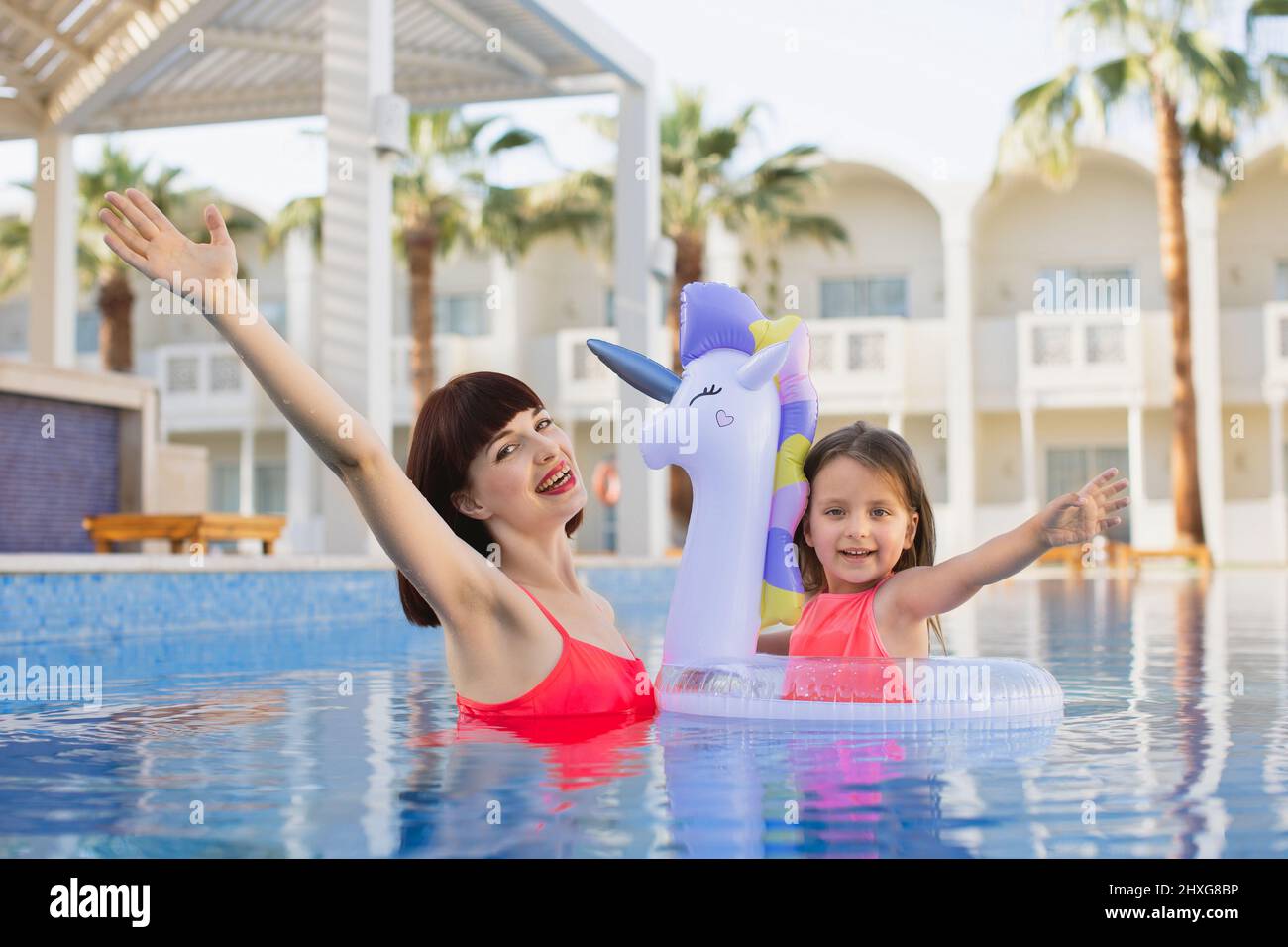 Junge schöne Frau und ihre kleine Tochter schwimmen im Pool des exotischen Luxus-Resorts. Ein ...
