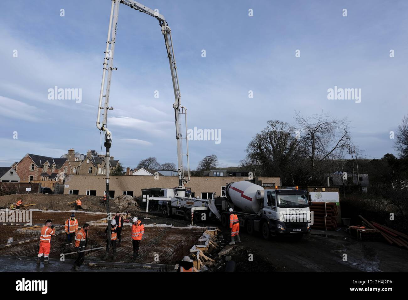 Arbeiter vor Ort im Hausbau, Gießen Betonunterlage aus einem Mischer ...