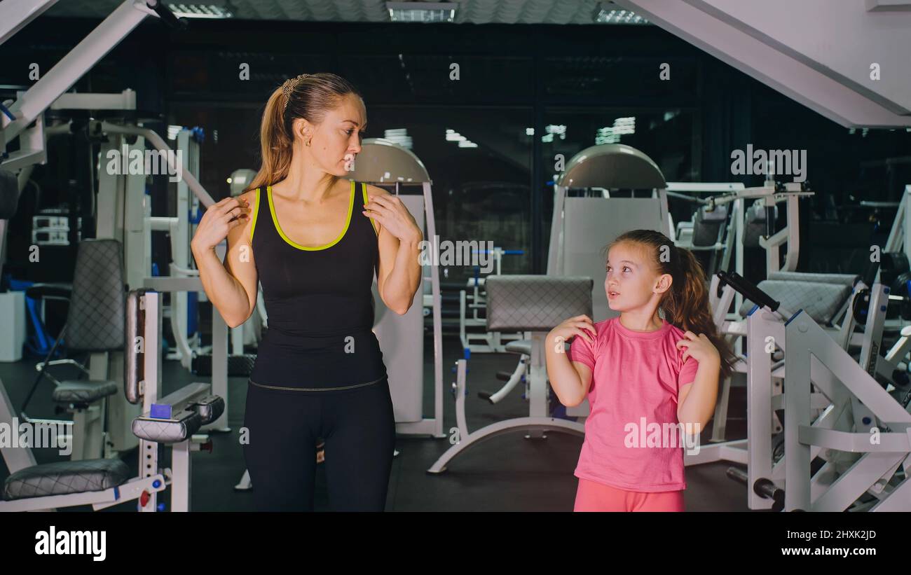 Mutter und Tochter im Fitnessstudio, Familie führt körperliche Übungen ...