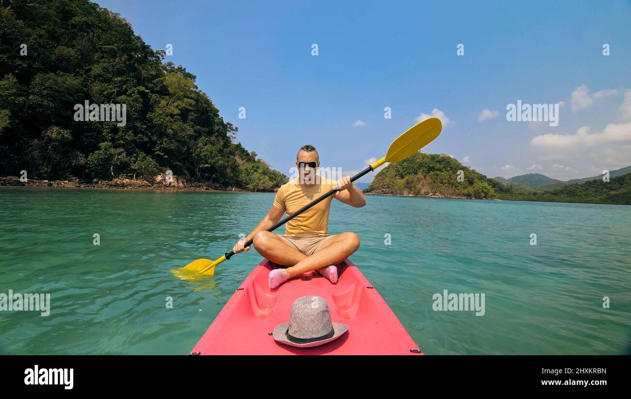 Junger Mann mit Sonnenbrille und Hut reiht sich mit einem rosa ...