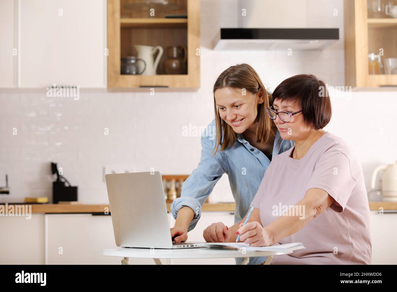 Junge Frau, die ältere Mutter lehrt, das Internet auf dem Laptop zu ...