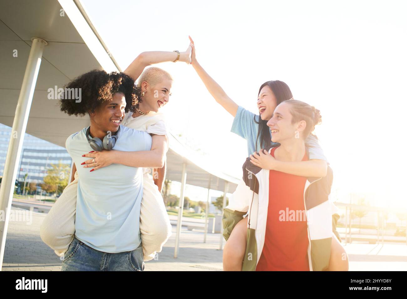 Centennals glückliche Freunde mit Huckepack und Stapeln der Hände auf ...