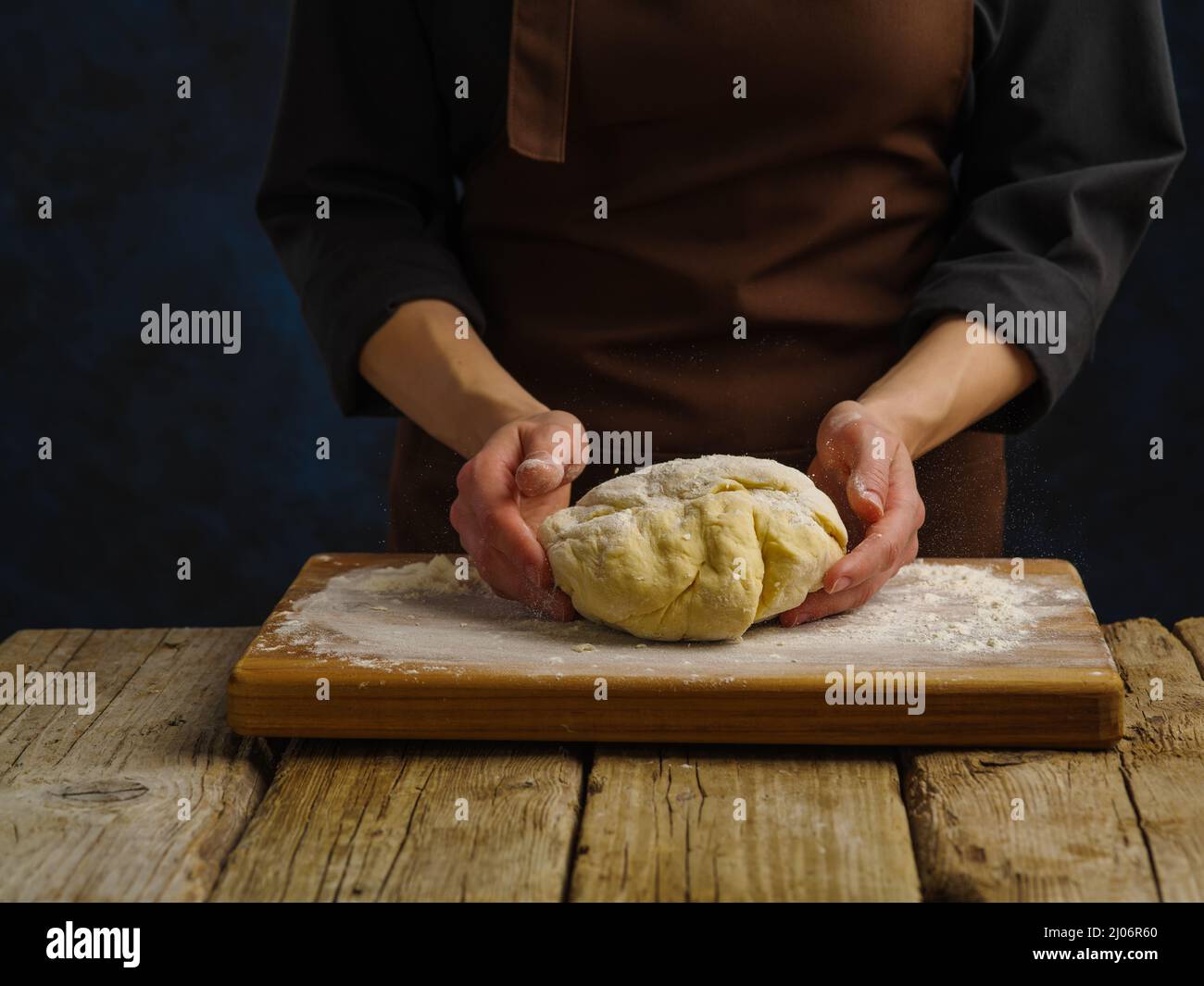 Teig, der von einem professionellen Koch auf einem Holztisch zubereitet ...