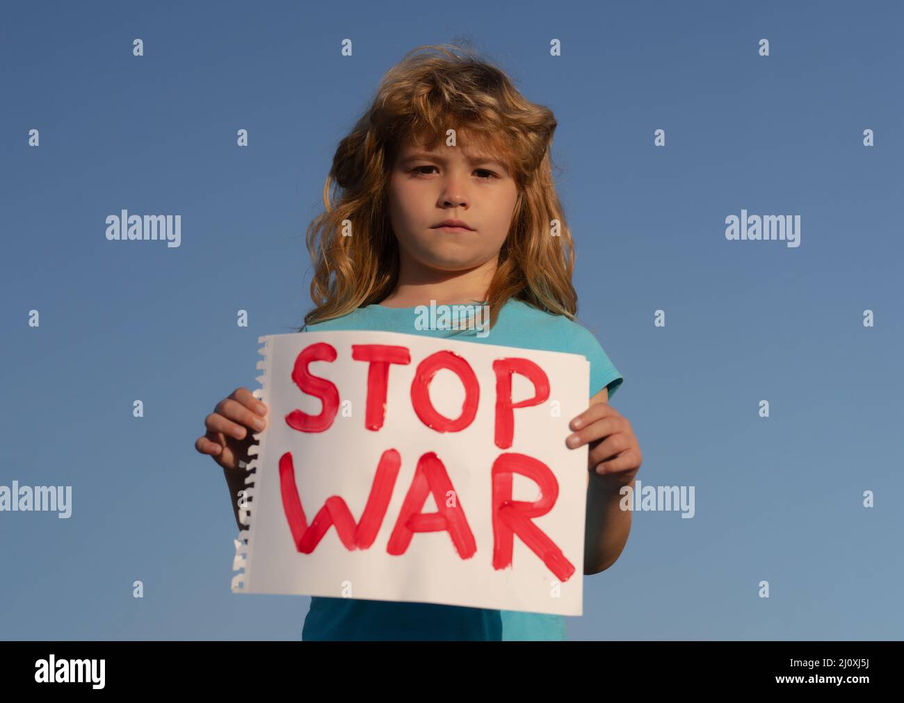 Kind trägt ein Schild Krieg stoppen. Portrait kleiner Junge ruft zu ...