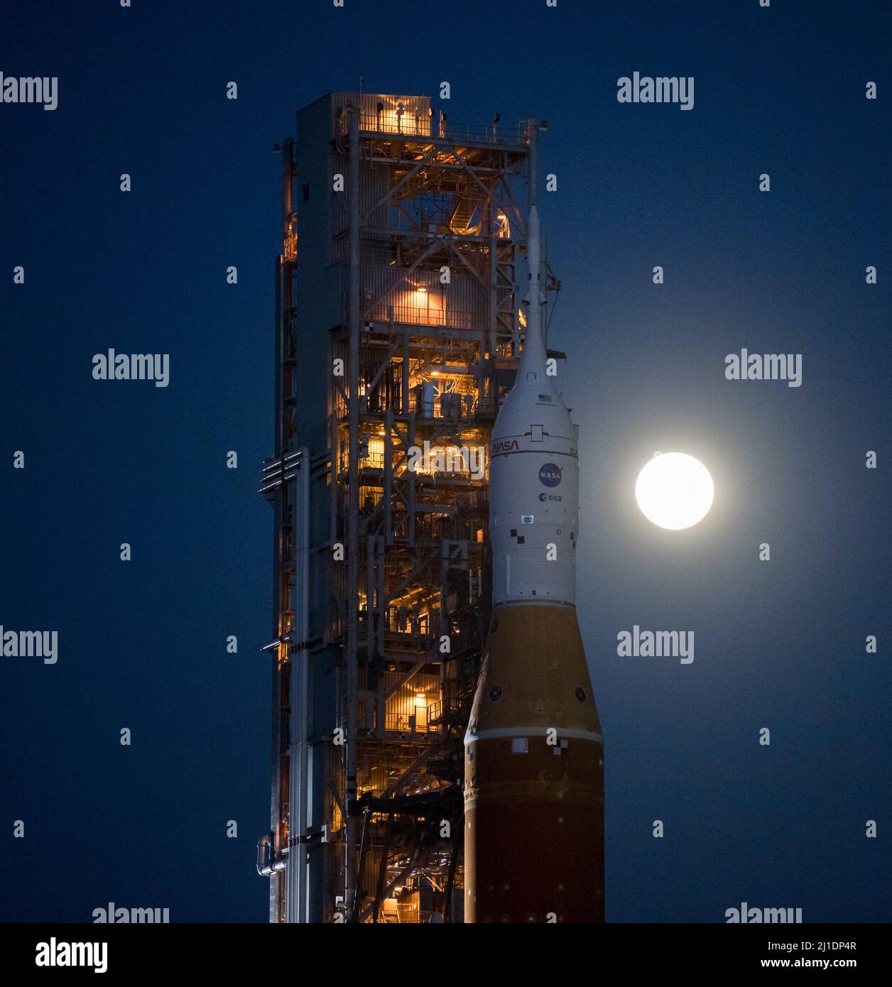 Der Mond steigt hinter der NASA-Rakete Space Launch System (SLS) mit ...