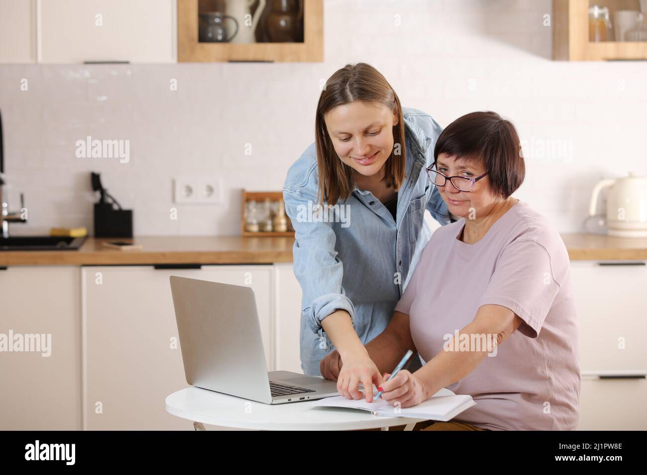 Junge Frau, die ältere Mutter lehrt, das Internet auf dem Laptop zu ...
