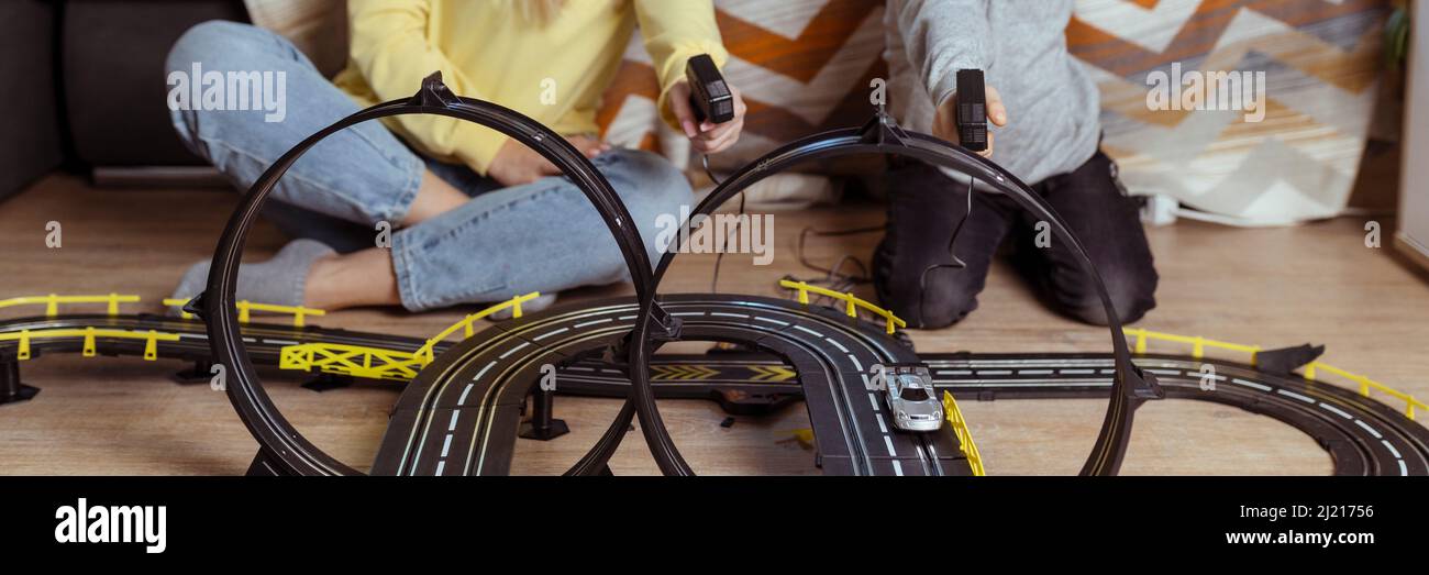 Mama und kleiner Sohn spielen zu Hause auf dem Teppich Rennen, haben ...