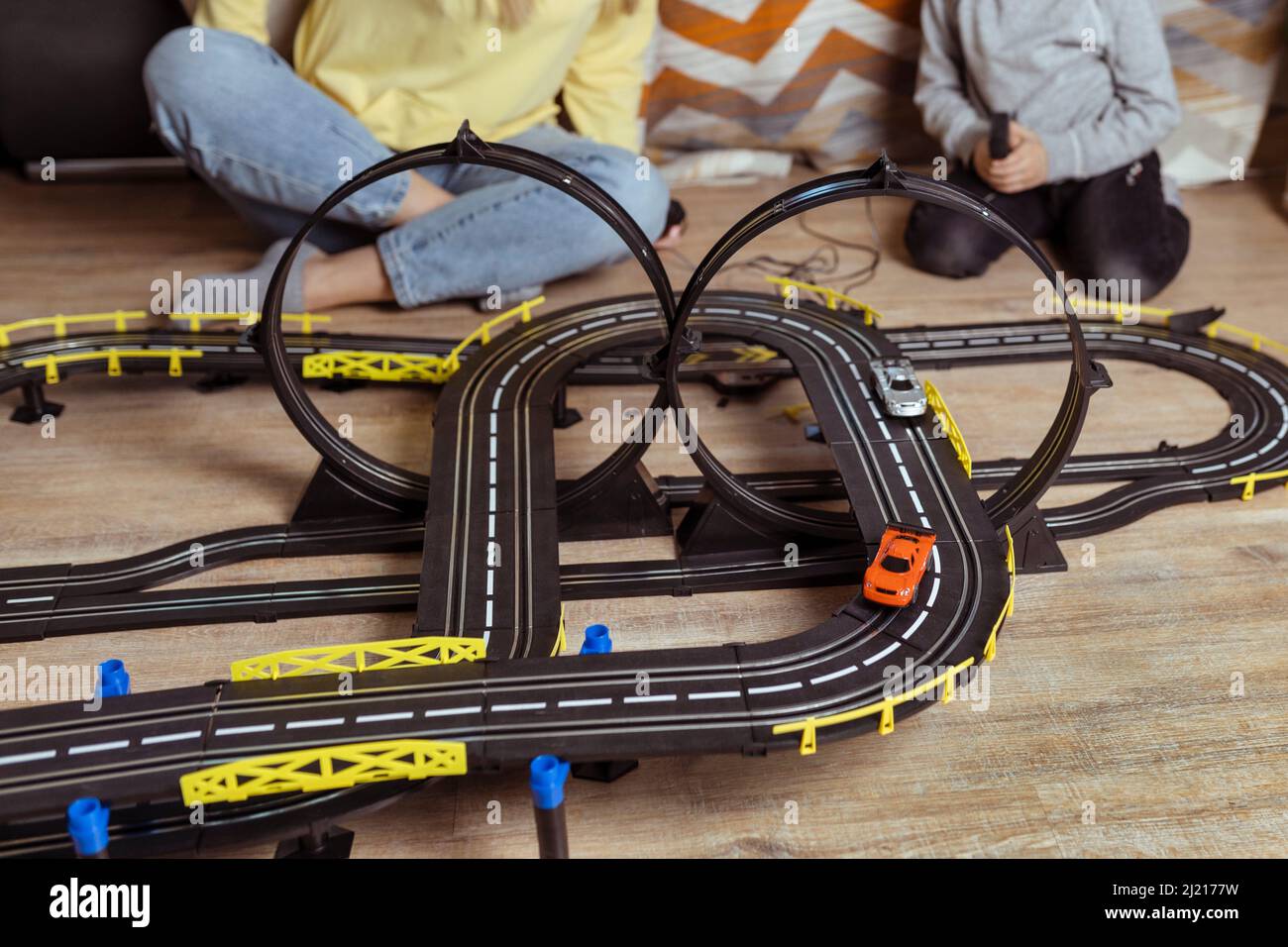Mama und kleiner Sohn spielen zu Hause auf dem Teppich Rennen, haben ...