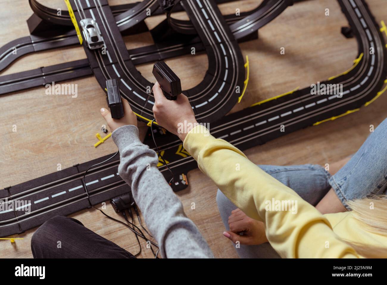 Mama und kleiner Sohn spielen zu Hause auf dem Teppich Rennen, haben ...