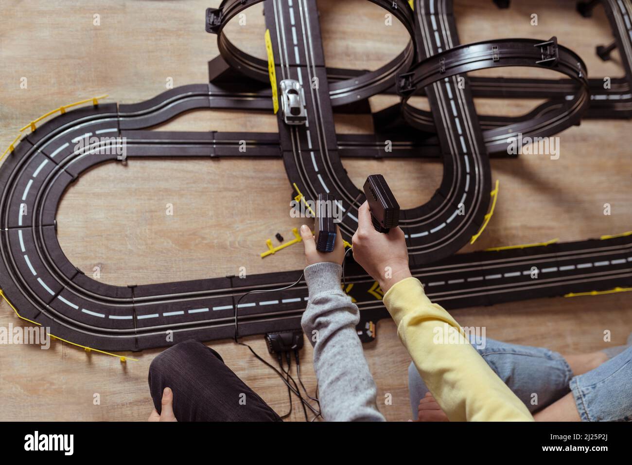 Mama und kleiner Sohn spielen zu Hause auf dem Teppich Rennen, haben ...