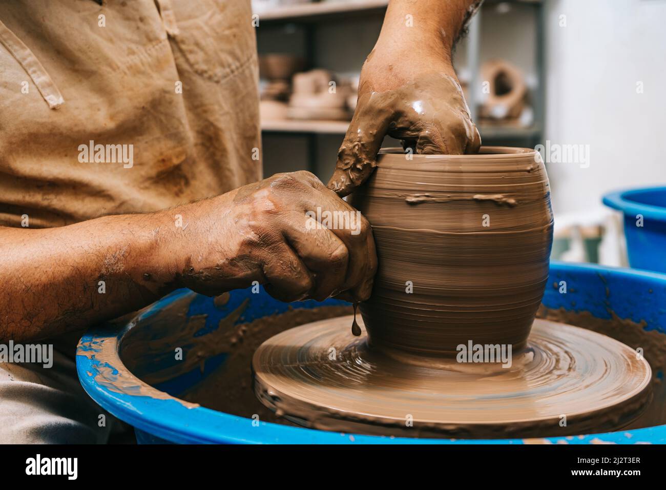 Die erfahrenen Hände eines Töpfers, der Ton auf einem Töpferrad ...