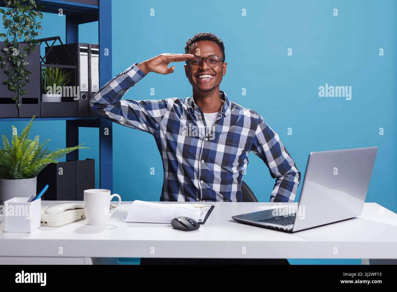 afroamerikanischer Mann, der beim Anschauen der Kamera im Büro einen ... afroamerikanischer Mann, der beim Anschauen der Kamera im Büro einen ...