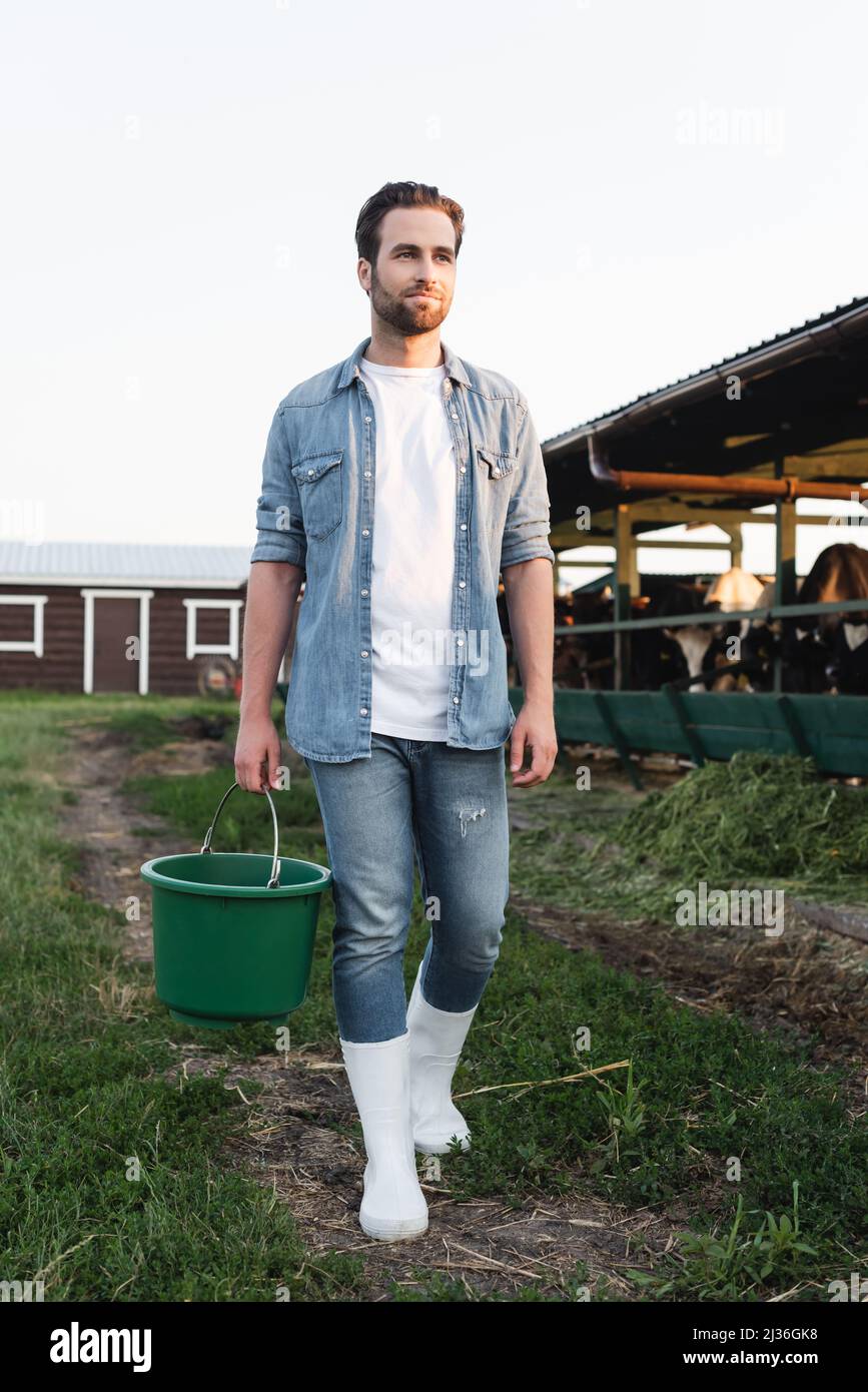 In voller Länge Ansicht von Landwirt in Denim-Kleidung und Gummistiefel ...