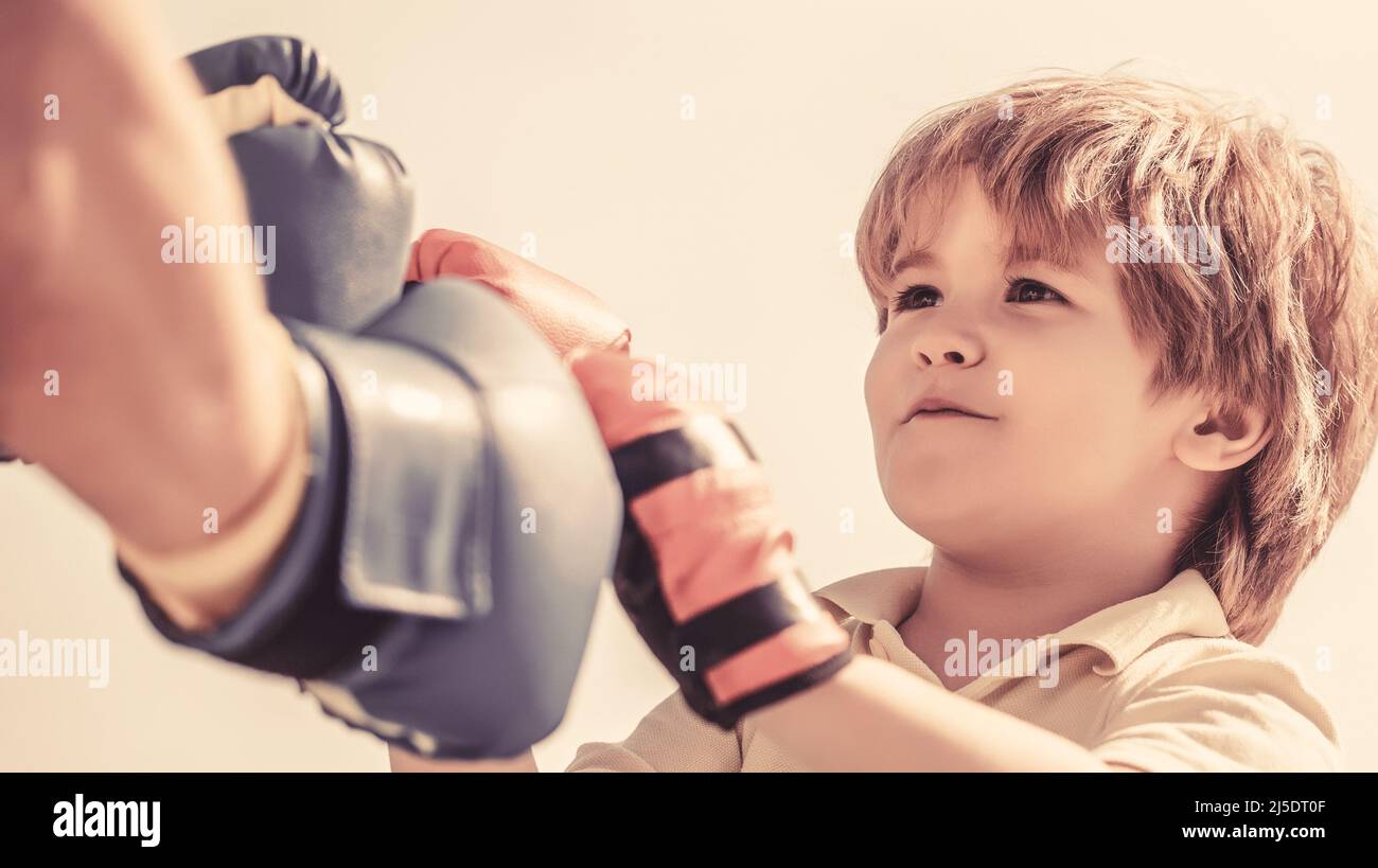 Vater trainiert seinen Sohn beim Boxen. Kleiner Junge tut Boxings Übung ...