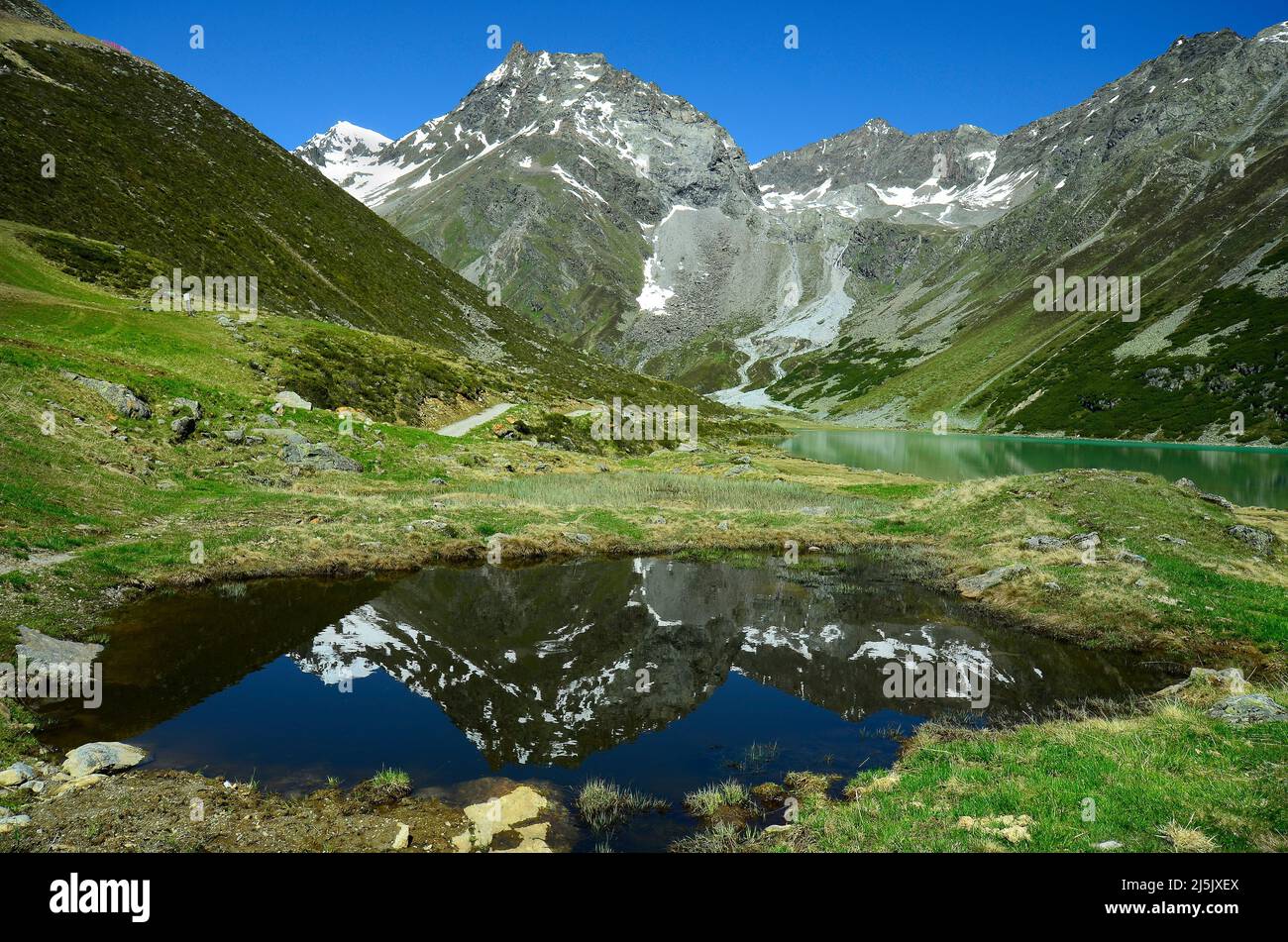 Österreich, Tirol, Reflexion der Tiroler Alpen in kleinen Pfütze und ...