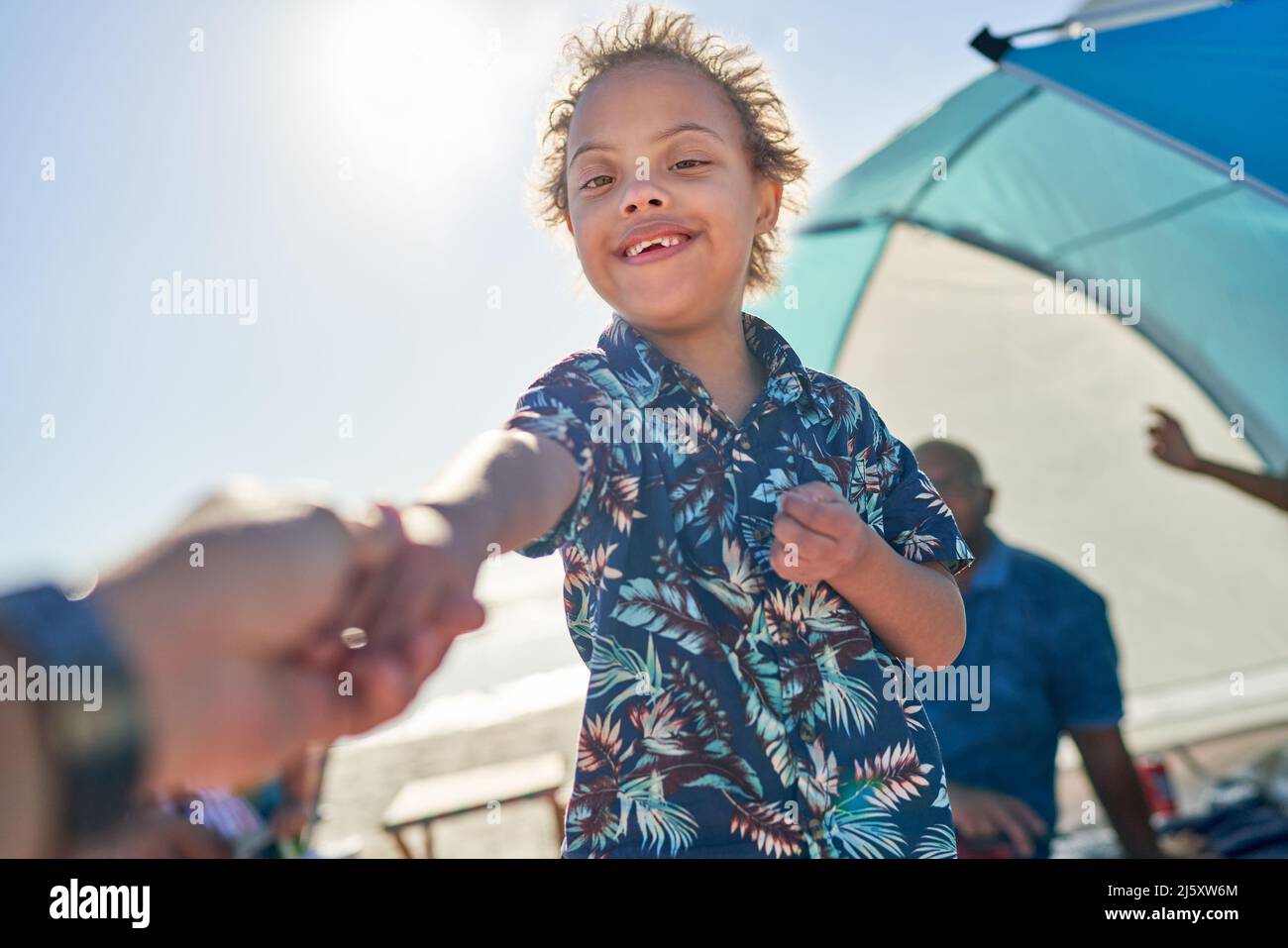 POV Portrait netter, glücklicher Junge mit Down-Syndrom, der die Hände ...
