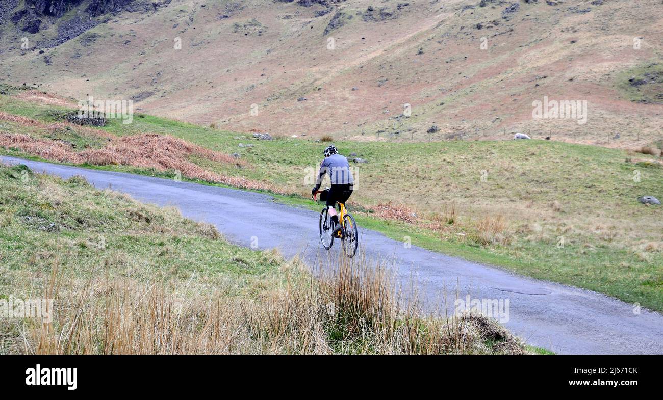 Ein Radfahrer beginnt mit der Fahrt auf den Hardknott Pass, einem der ...