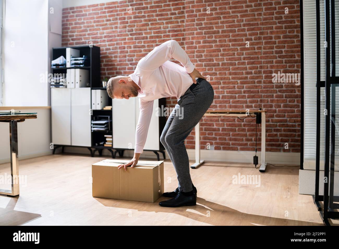 Man lifting heavy box -Fotos und -Bildmaterial in hoher Auflösung – Alamy