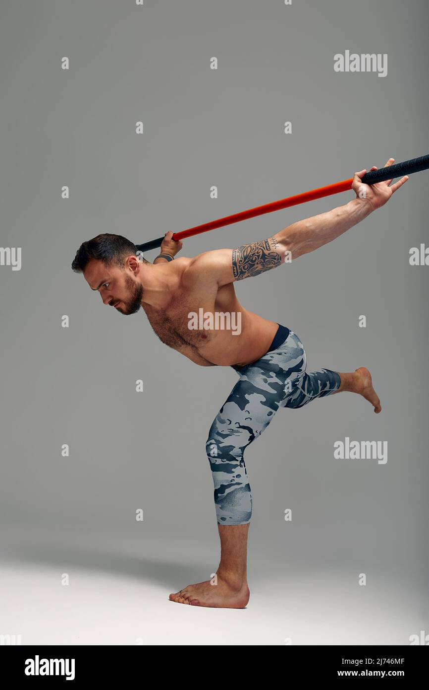 Ein Ninja-Mann hält sich an einen Kampfstock und greift Nahaufnahmen ...