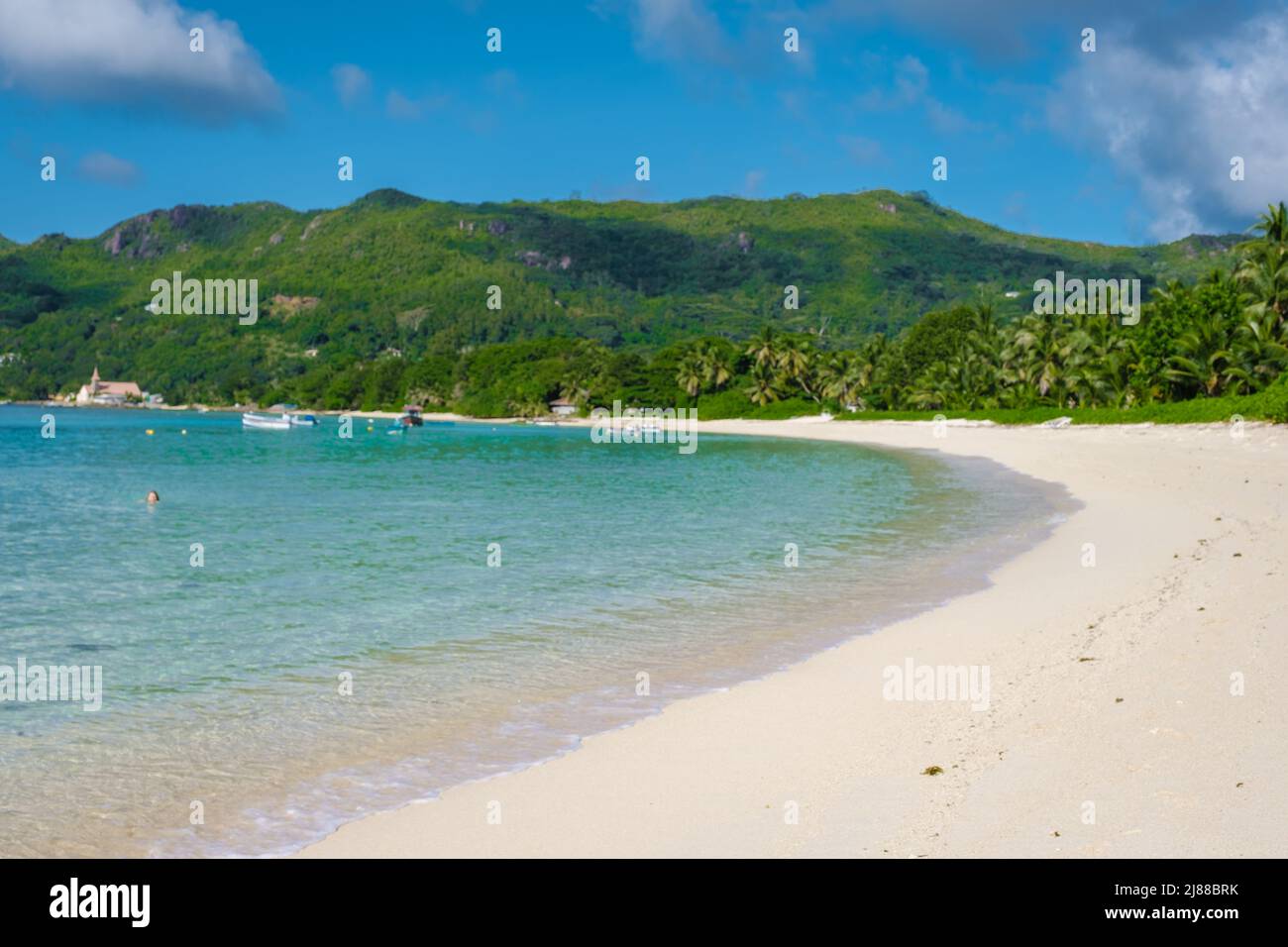 Mahe Seychellen, ein tropischer Strand mit Palmen und ein blaues Meer ...