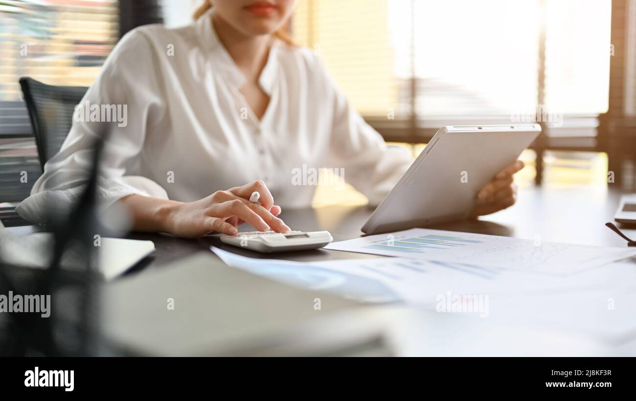 Eine buchhalterin bei der arbeit im buero mit taschenrechner -Fotos und ...