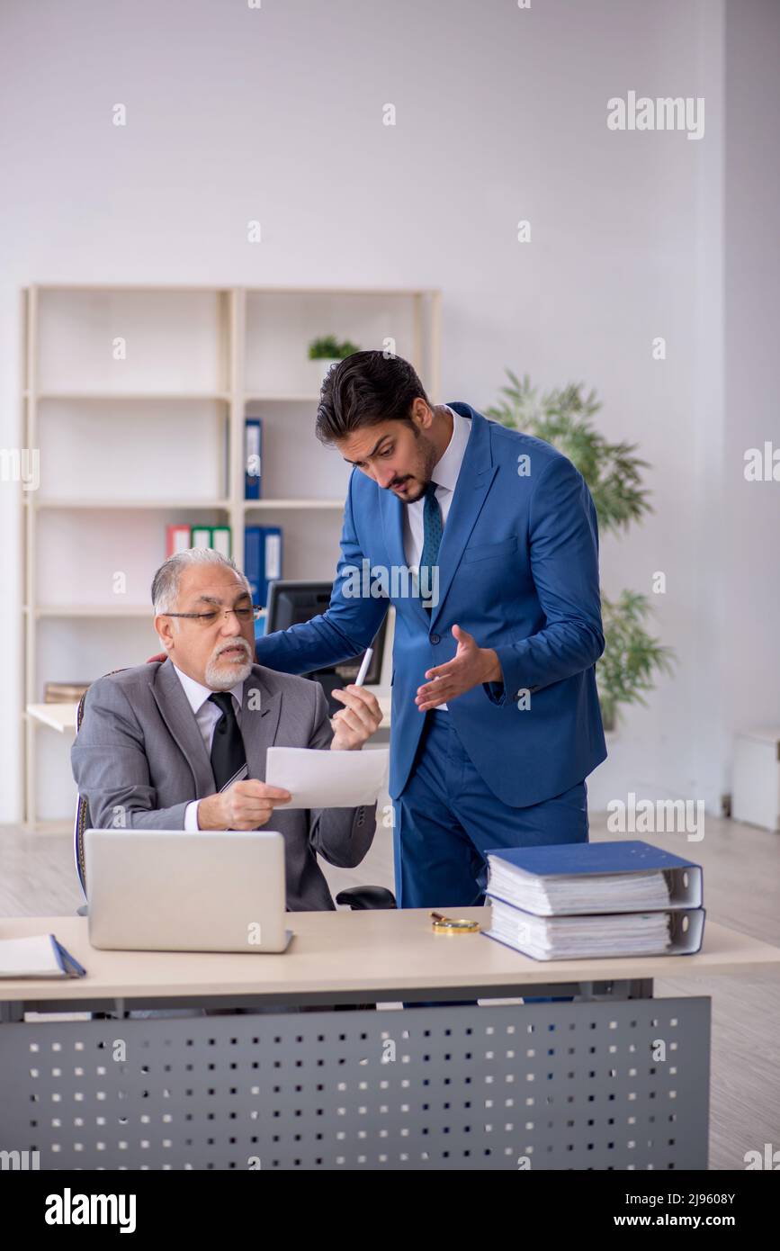 Alter Chef und junger Mitarbeiter am Arbeitsplatz Stockfotografie - Alamy