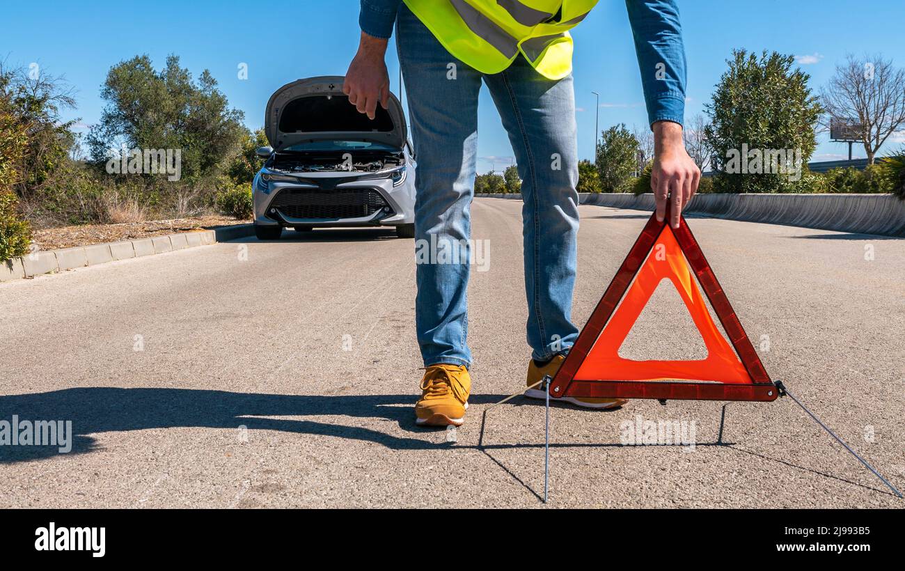 Auto mit Problemen und Mann legte ein rotes Dreieck, um andere ...