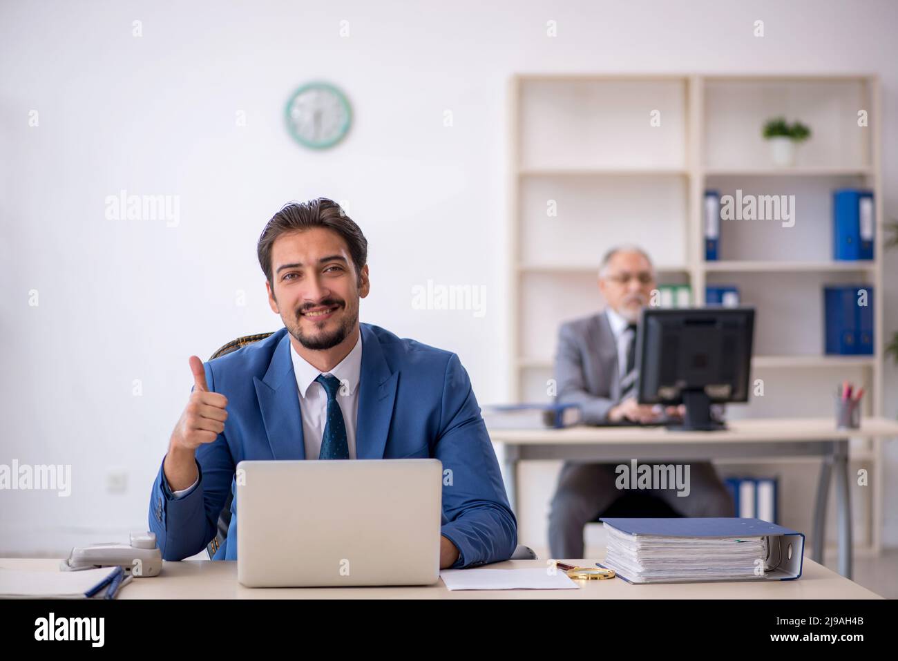 Alter Chef und junger Mitarbeiter am Arbeitsplatz Stockfotografie - Alamy