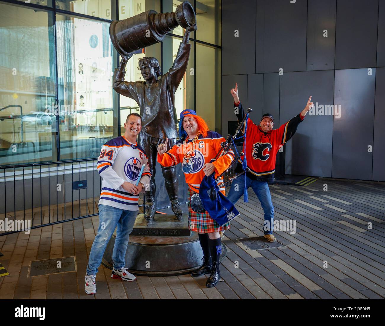 Edmonton Oilers-Fans posiert unter einer Statue von Wayne Gretzky, als ...