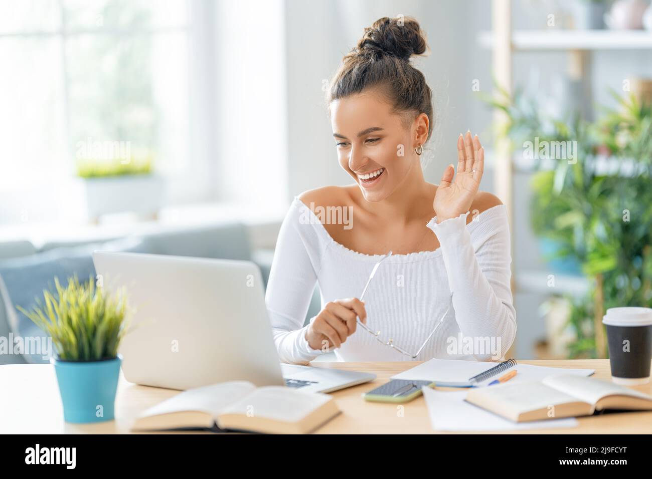 Glückliche junge Geschäftsfrau, die online studiert, Webinar ansieht ...