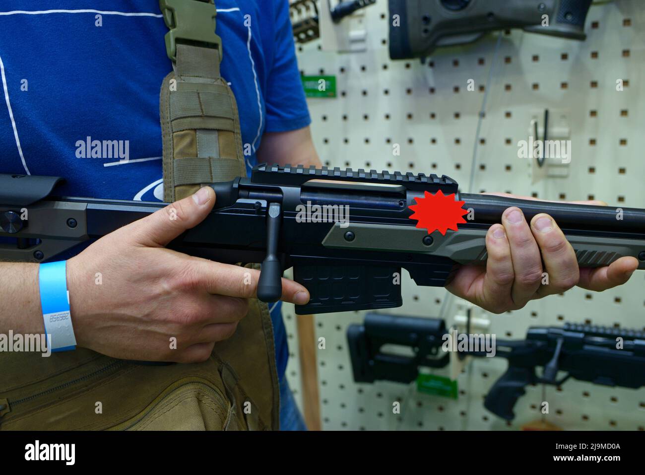Mann hält ein neues Modell eines Gewehr in einem Waffenladen, Gewehre ...
