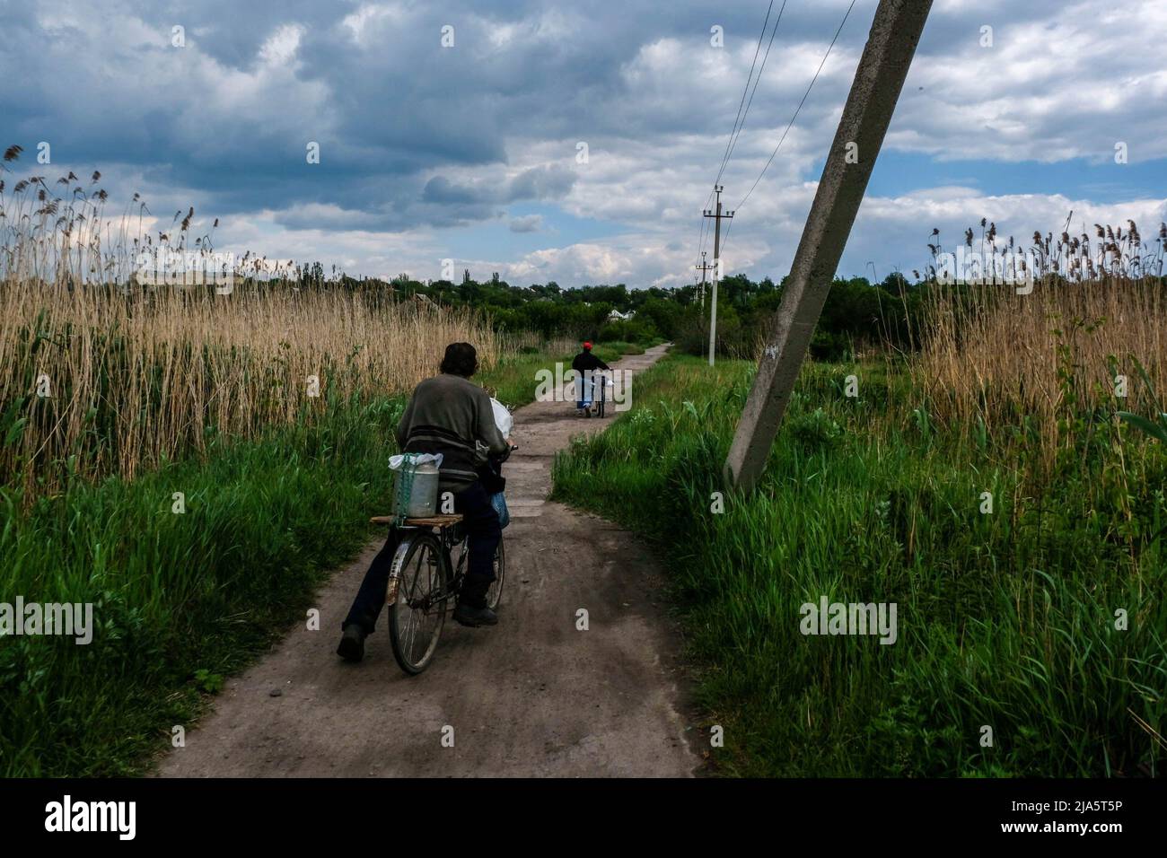 Siversk, Ukraine. 27.. Mai 2022. Menschen gehen mit Fahrrädern, um ...