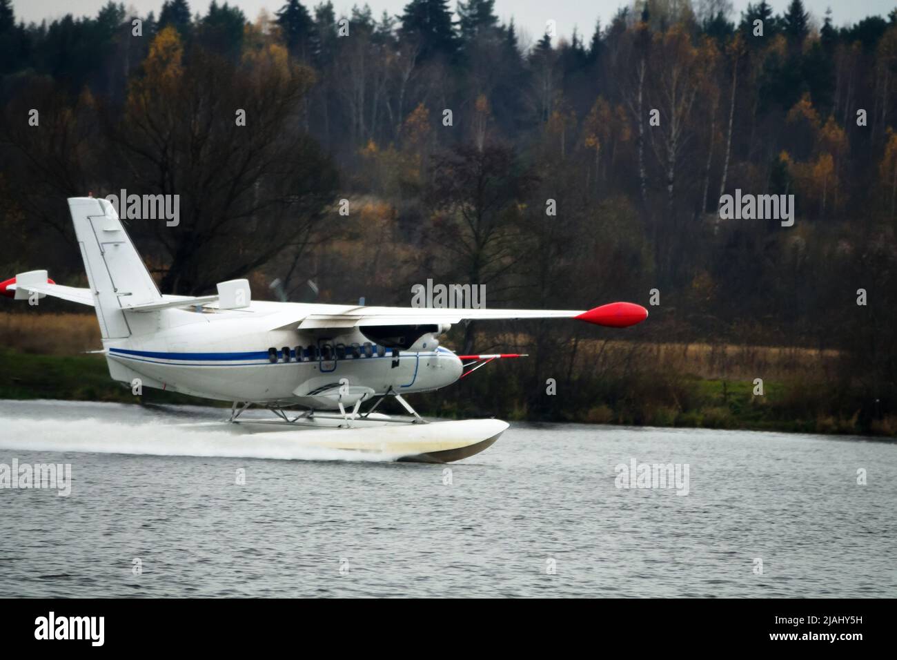 Das zweimotorige Wasserflugzeug ein Wasserflugzeug steigt aus dem ...