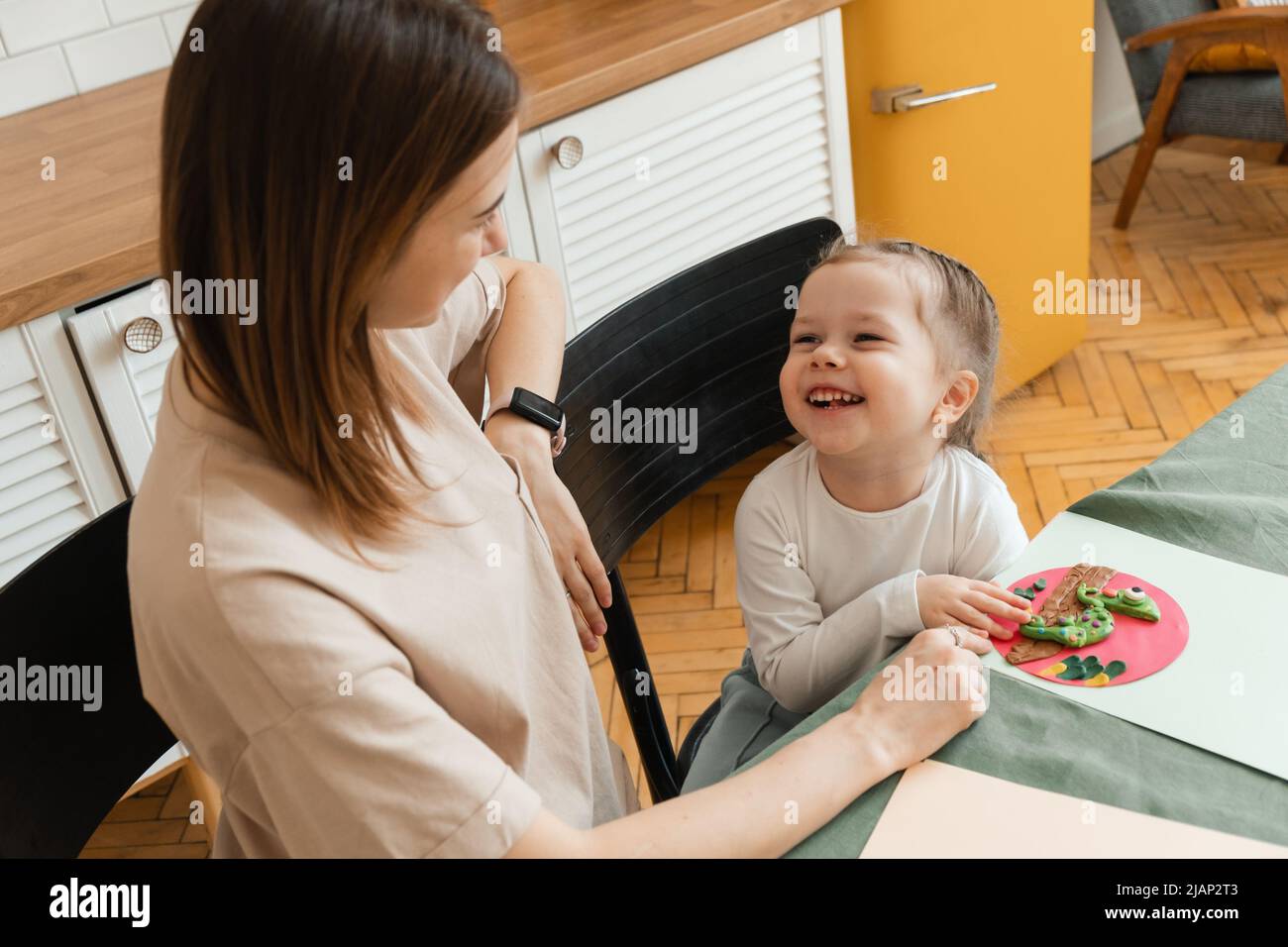 Nette Mutter und Tochter machen zu Hause Handwerk. Ein junges ...