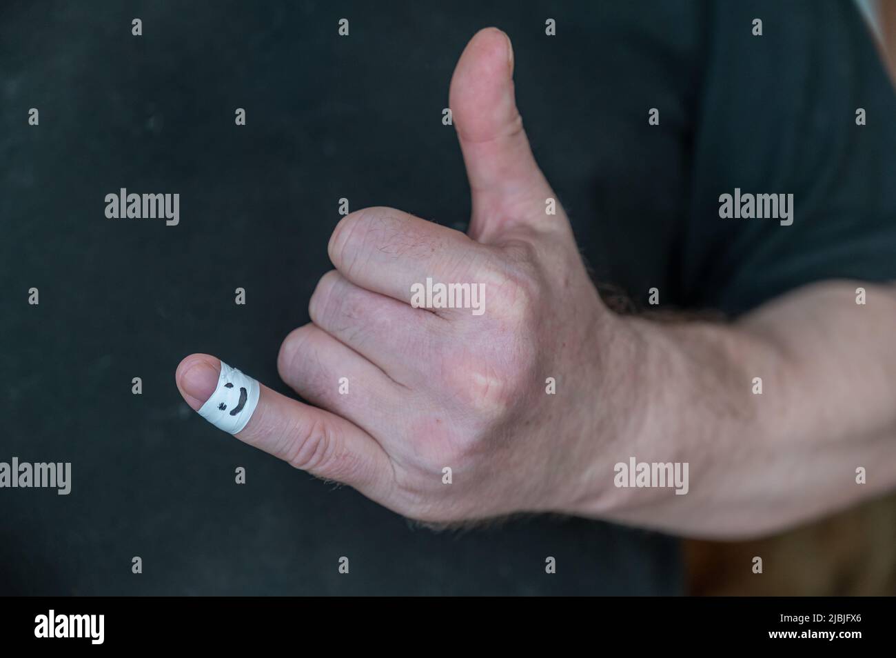 Der Mann zeigt seine Hand mit Daumen nach oben. Die erste Pals seines ...