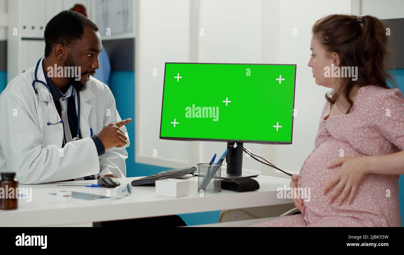 Medic und Patient mit Schwangerschaft Bauch Blick auf Greenscreen auf ...