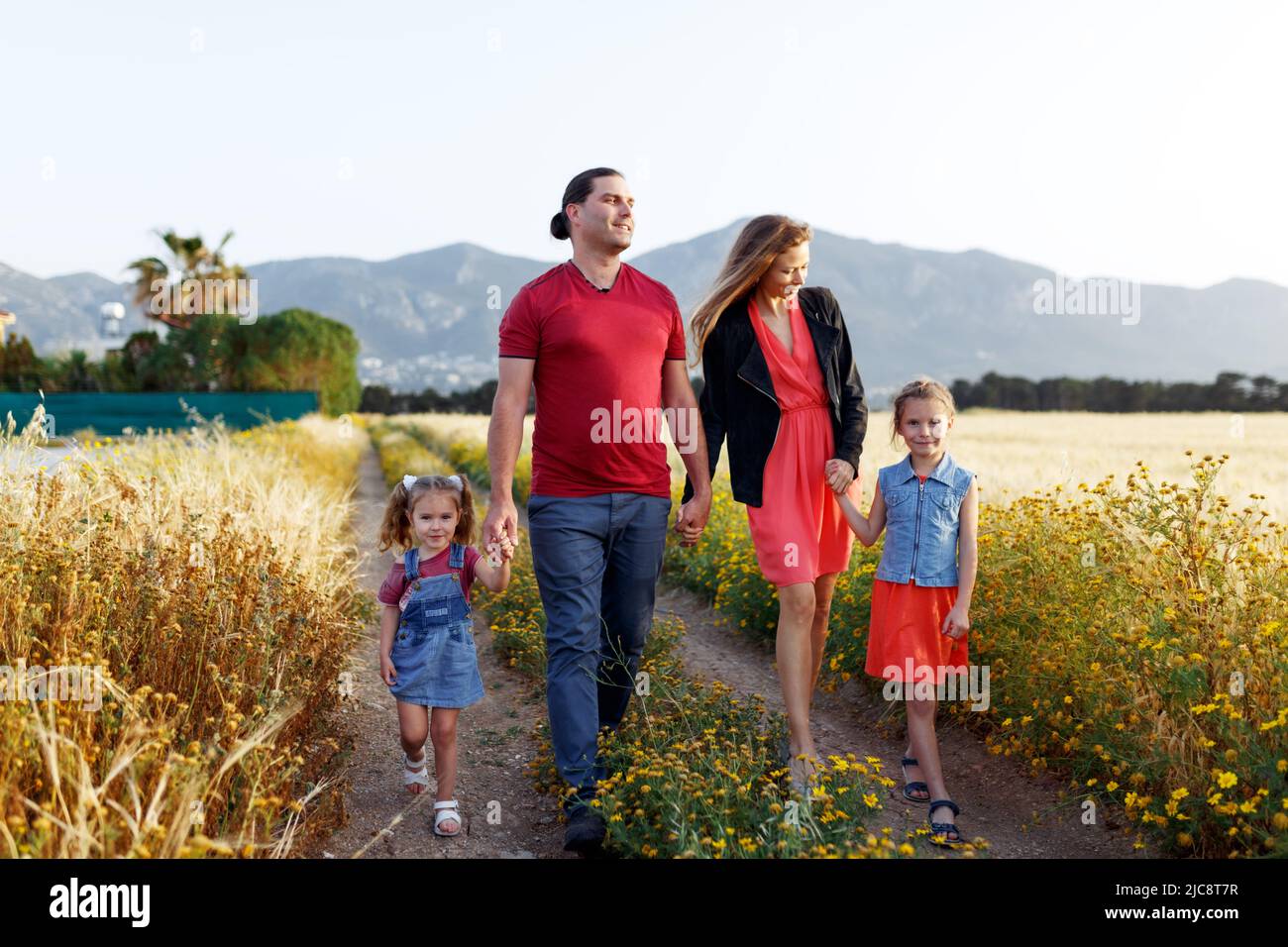 Glückliche Familie Vater der Mutter und zwei Töchter Schwestern zu Fuß auf dem Land Natur bei ...