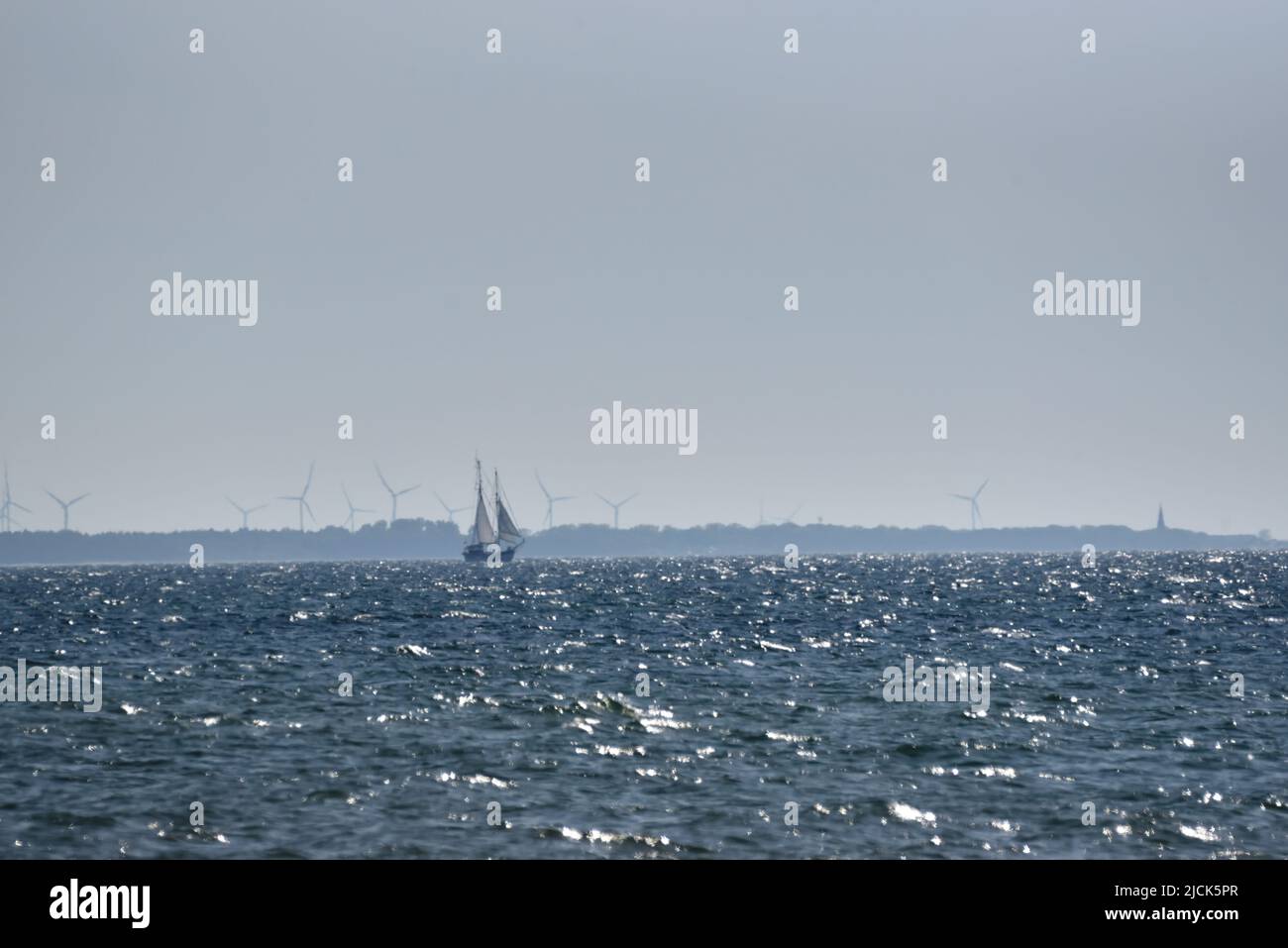 Ein zweimastiger Segelschiff, der in der Nähe des Ufers segelt, können ...
