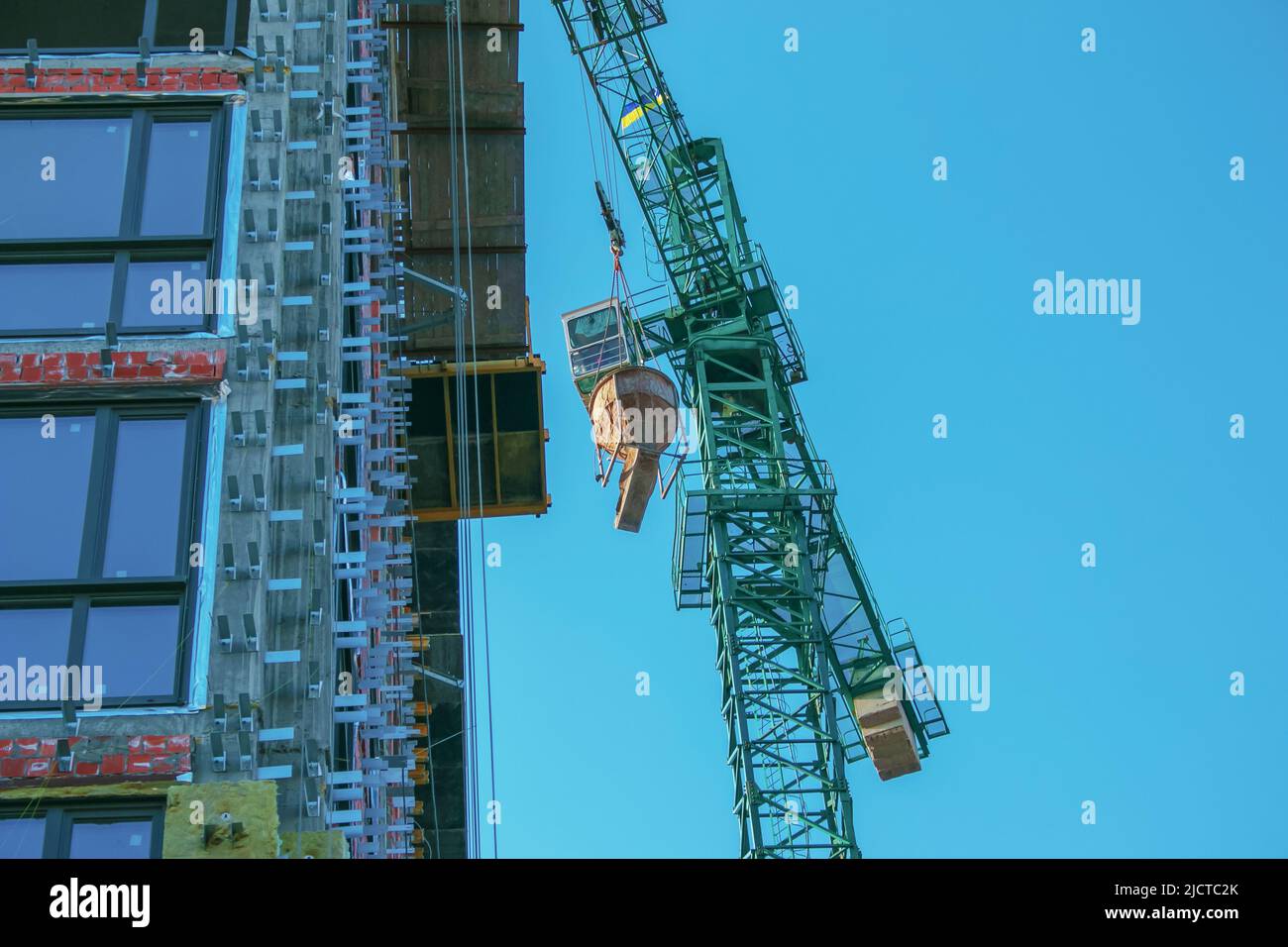 Ein Kran hebt Beton für eine moderne Metall-Beton-Struktur eines ...