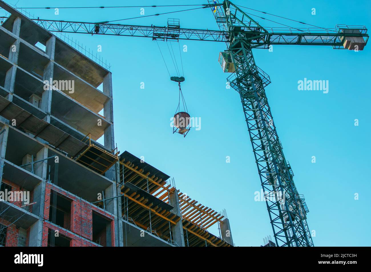 Ein Kran hebt Beton für eine moderne Metall-Beton-Struktur eines ...
