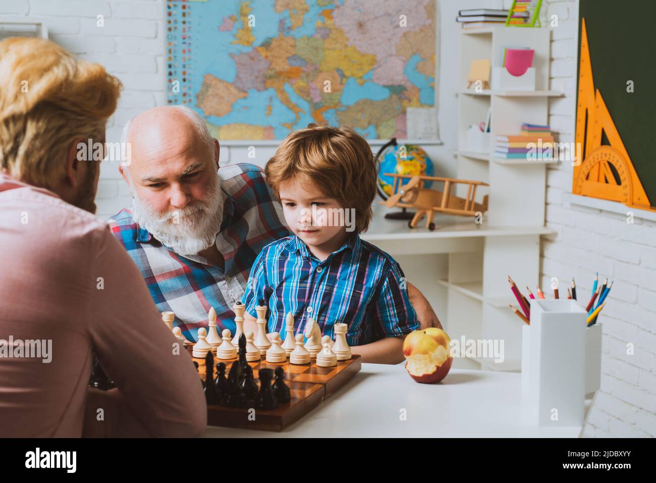 Vatertag. Großvater Vater und Sohn spielen Schach, Männer Generation ...