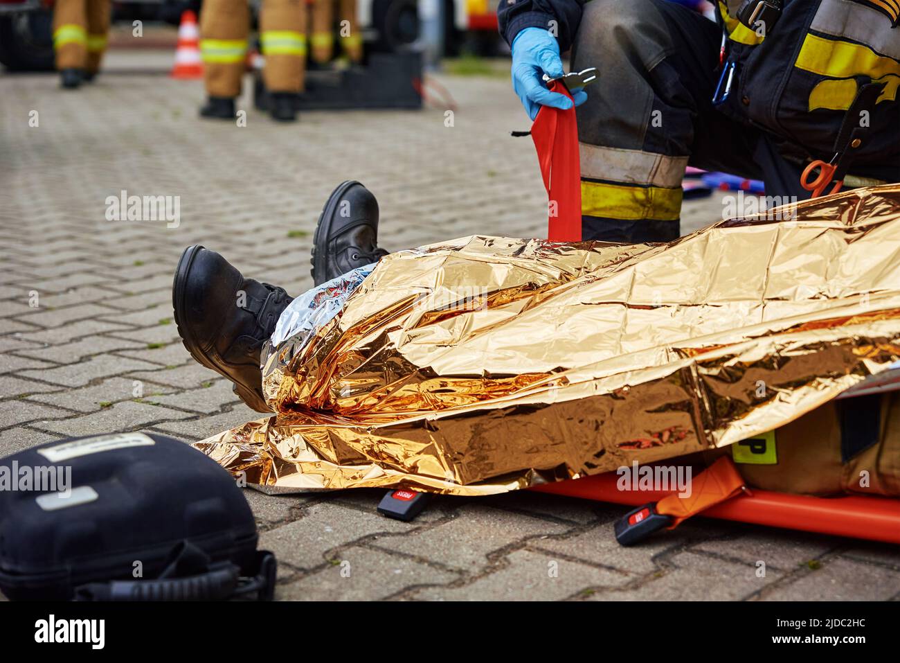 Rettungskräfte leisten dem Opfer während eines Autounfalls erste Hilfe. Die durch den Unfall ...